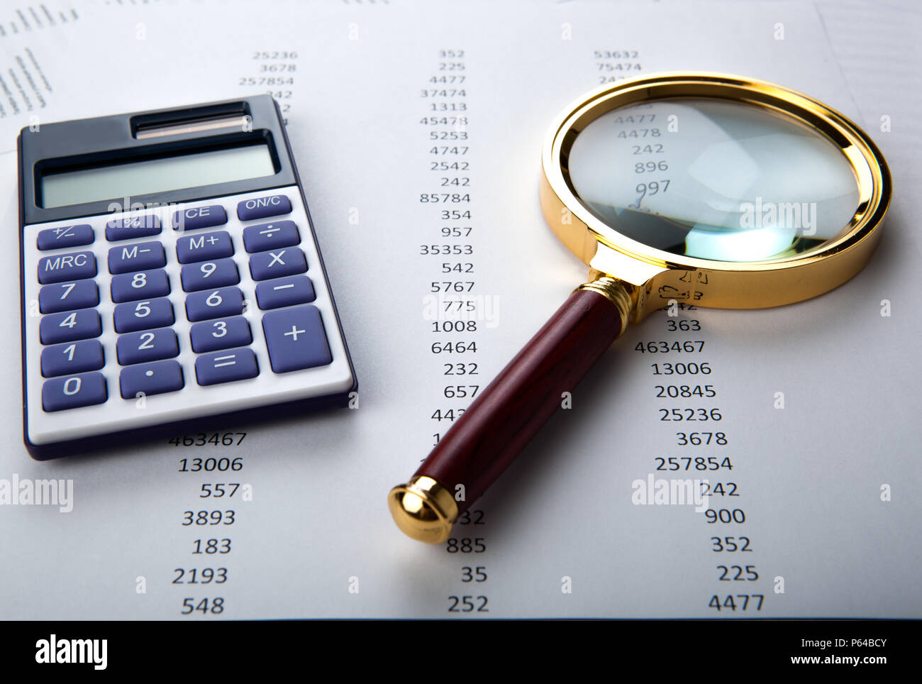 work with a magnifying glass, a calculator and papers Stock Photo - Alamy