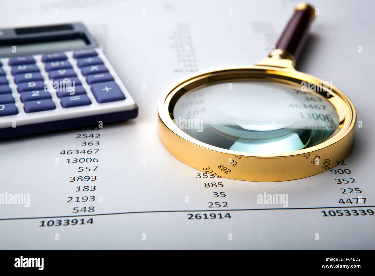 work with a magnifying glass, a calculator and papers Stock Photo - Alamy