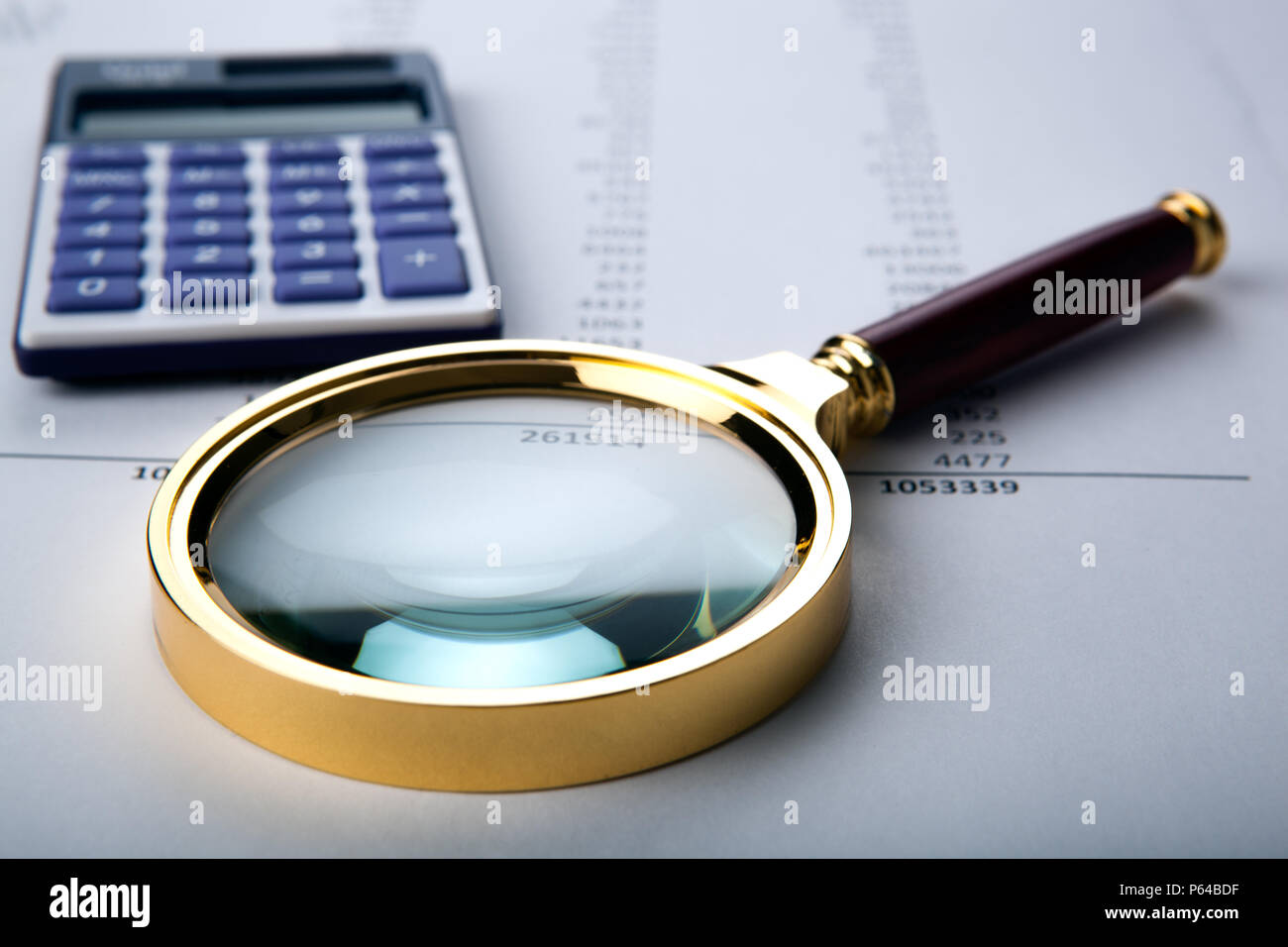 work with a magnifying glass, a calculator and papers Stock Photo - Alamy