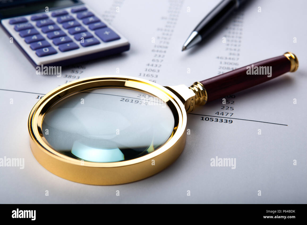 work with a magnifying glass, a calculator and papers Stock Photo - Alamy