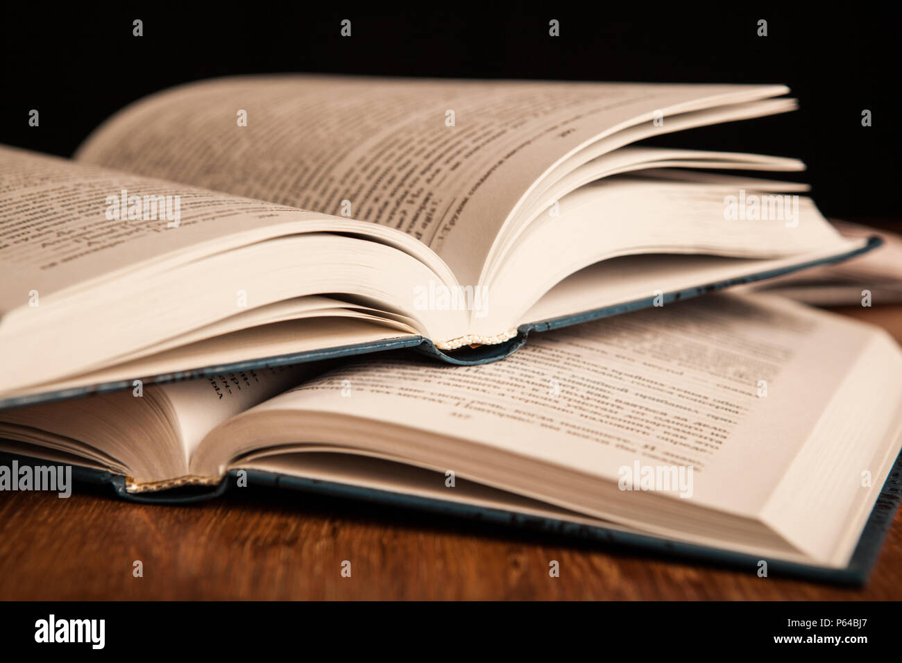 stack of open books on a wood background Stock Photo - Alamy