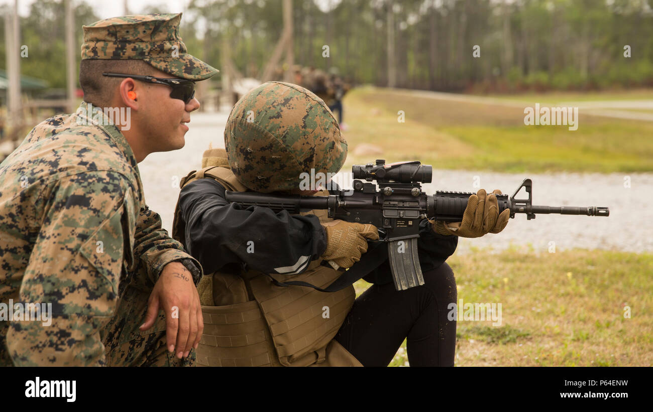 Olivia Shane, a spouse, accurately shoots the target from the kneeling ...
