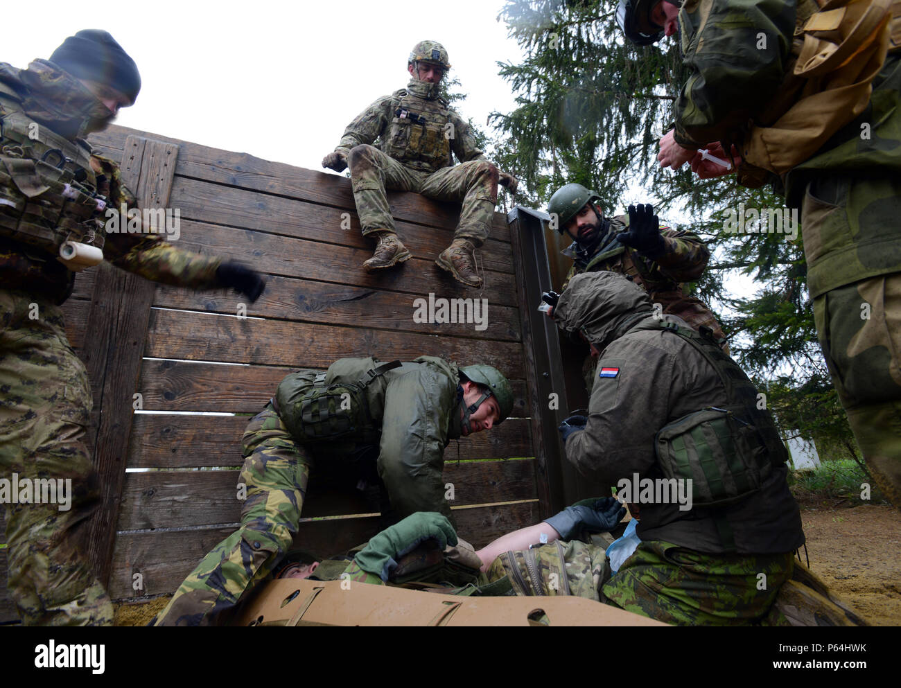 Soldiers from various nations work together to maneuver a simulated ...