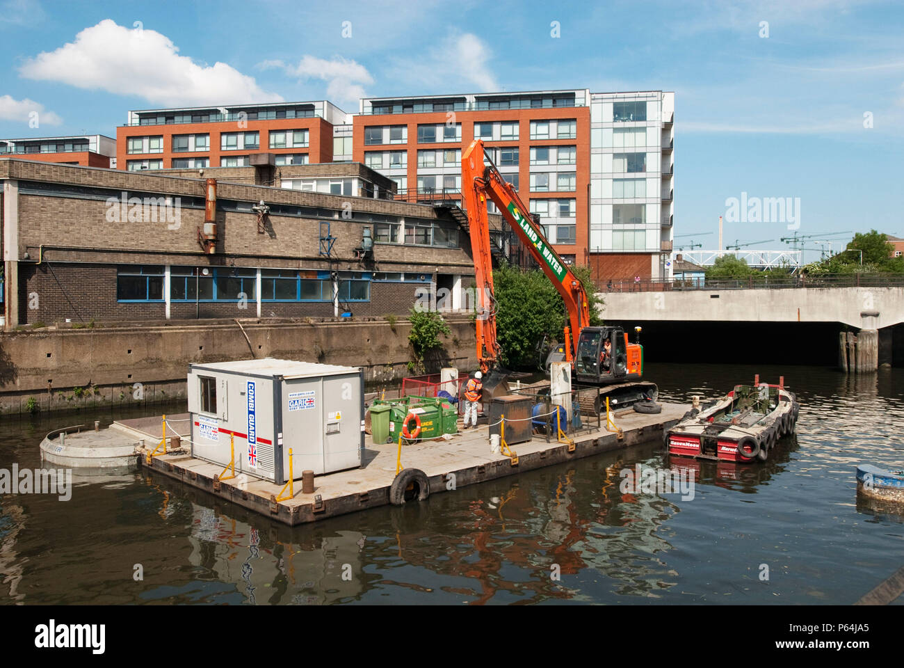 Floating platform with excavator and barge on the Lower Lea canal ...