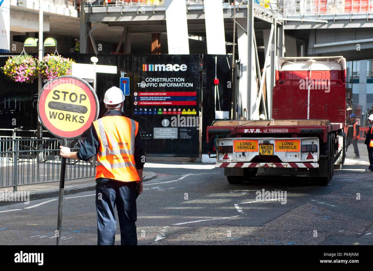 A marshall stopping traffic to allow a lorry to reverse out of a ...