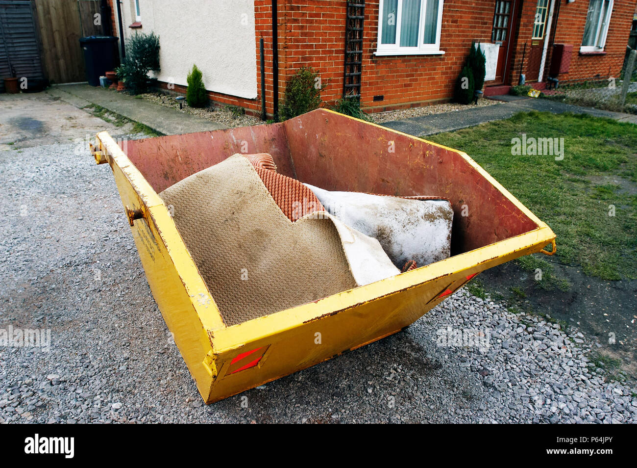 Skip in front of a house under refurbishment Stock Photo - Alamy