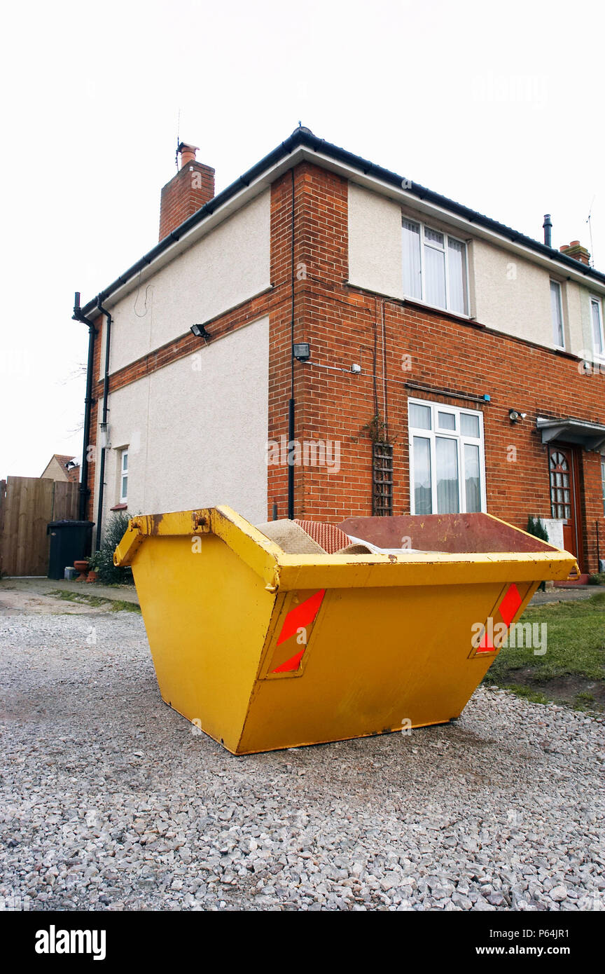 Skip in front of a house under refurbishment Stock Photo - Alamy