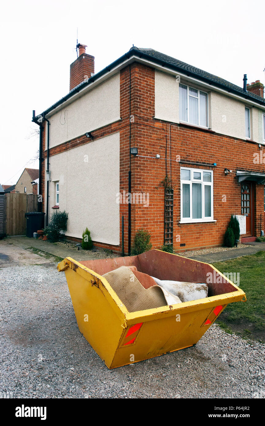 Skip in front of a house under refurbishment Stock Photo - Alamy