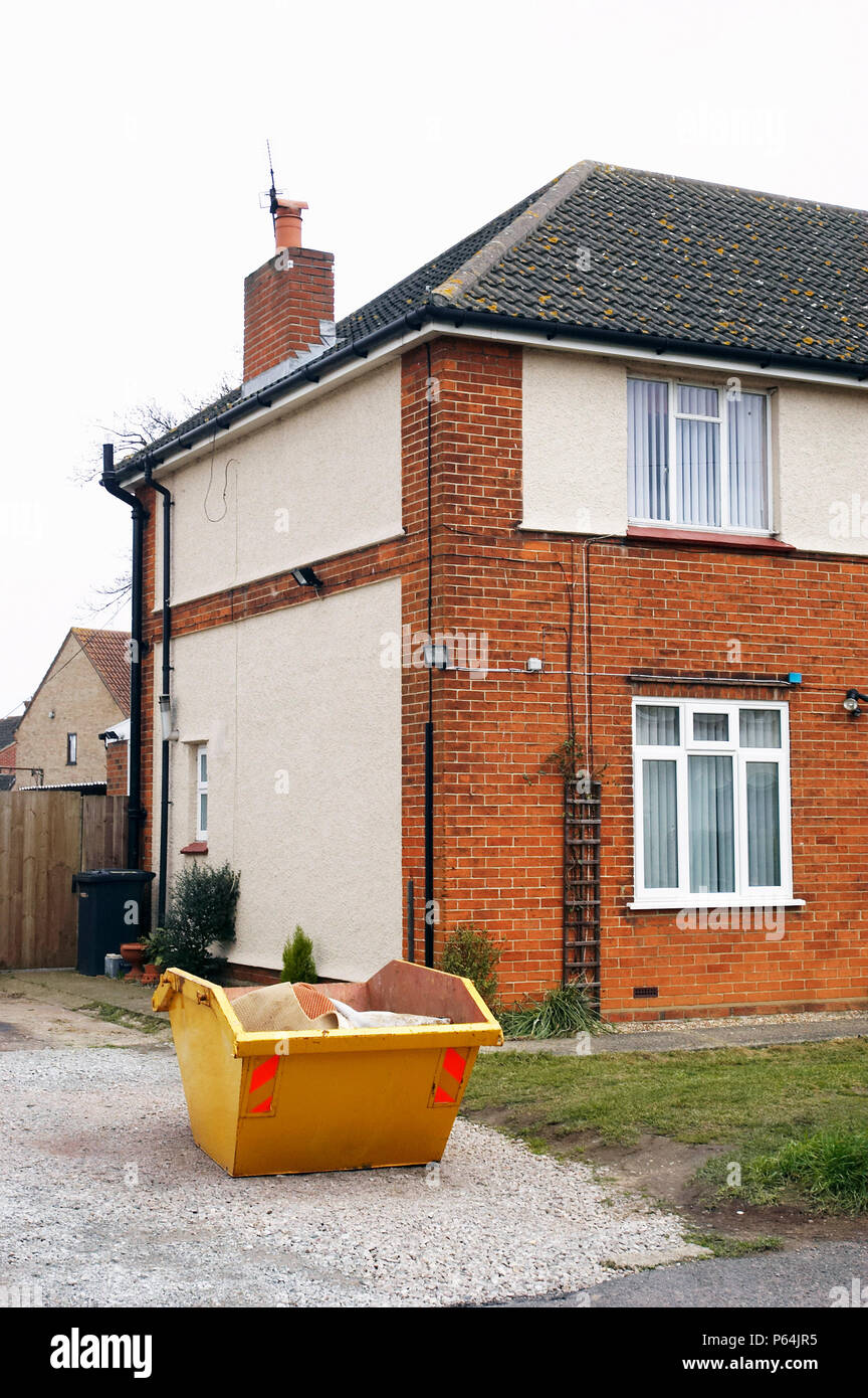 Skip in front of a house under refurbishment Stock Photo - Alamy