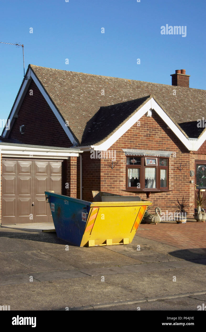 Skip in driveway of home, UK Stock Photo - Alamy