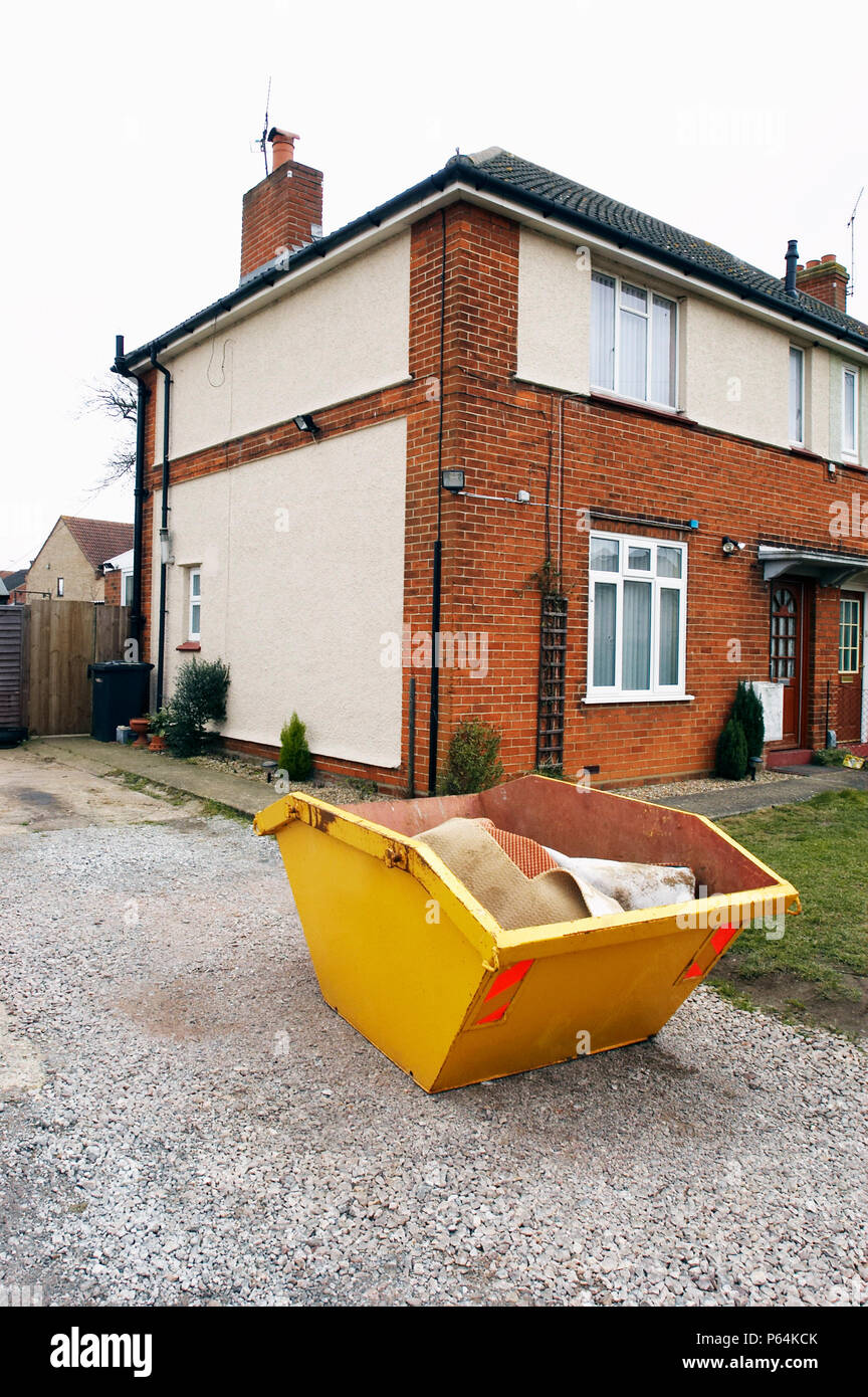 Skip in front of a house under refurbishment Stock Photo - Alamy