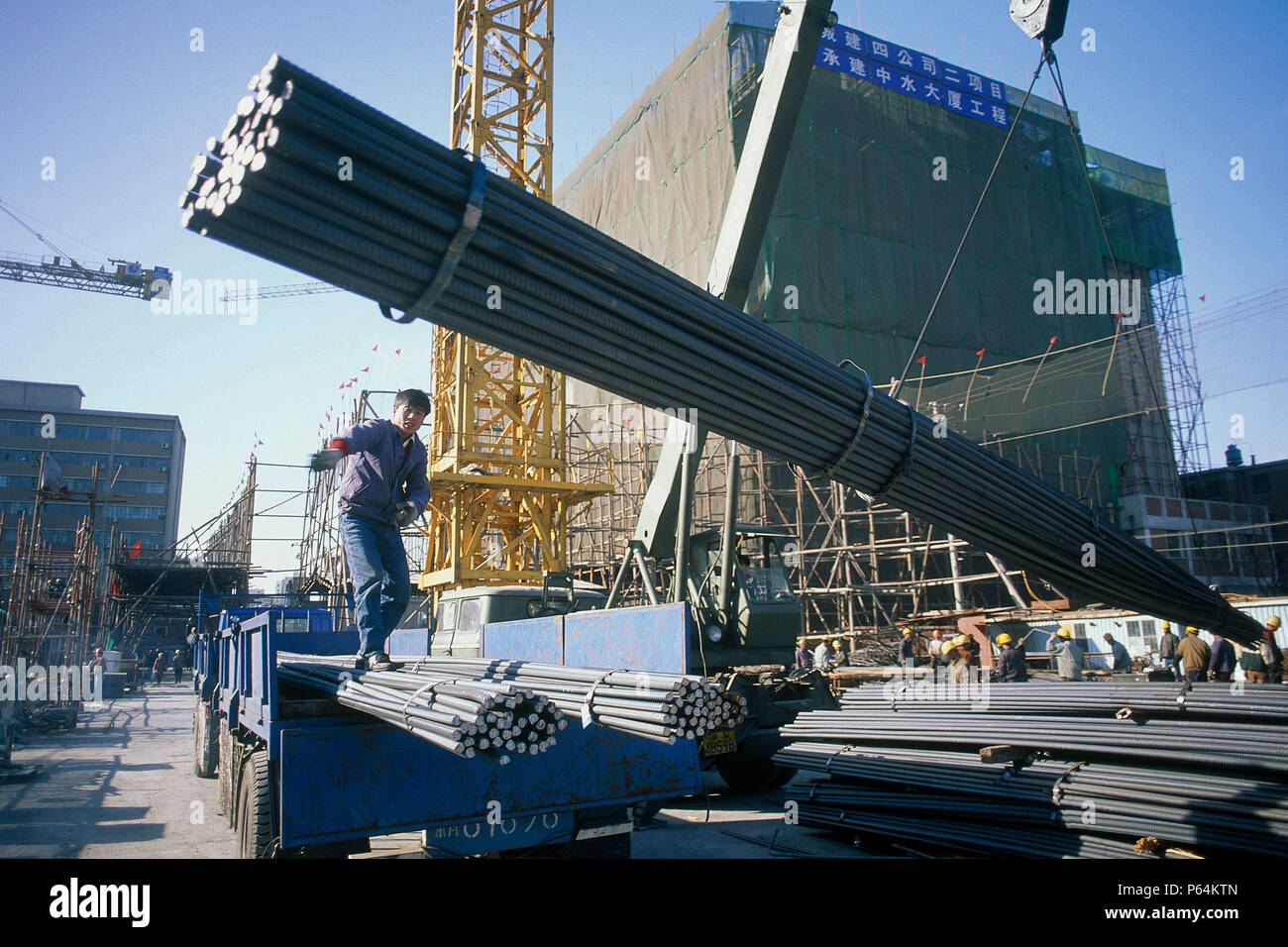 Unloading steel reinforcement bundle from lorry by crane at office ...