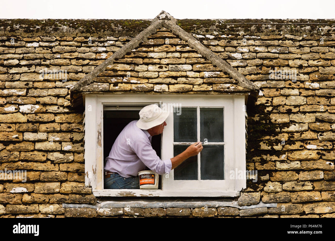 Painting the cottage dormer window, Gloucestershire, England Stock ...