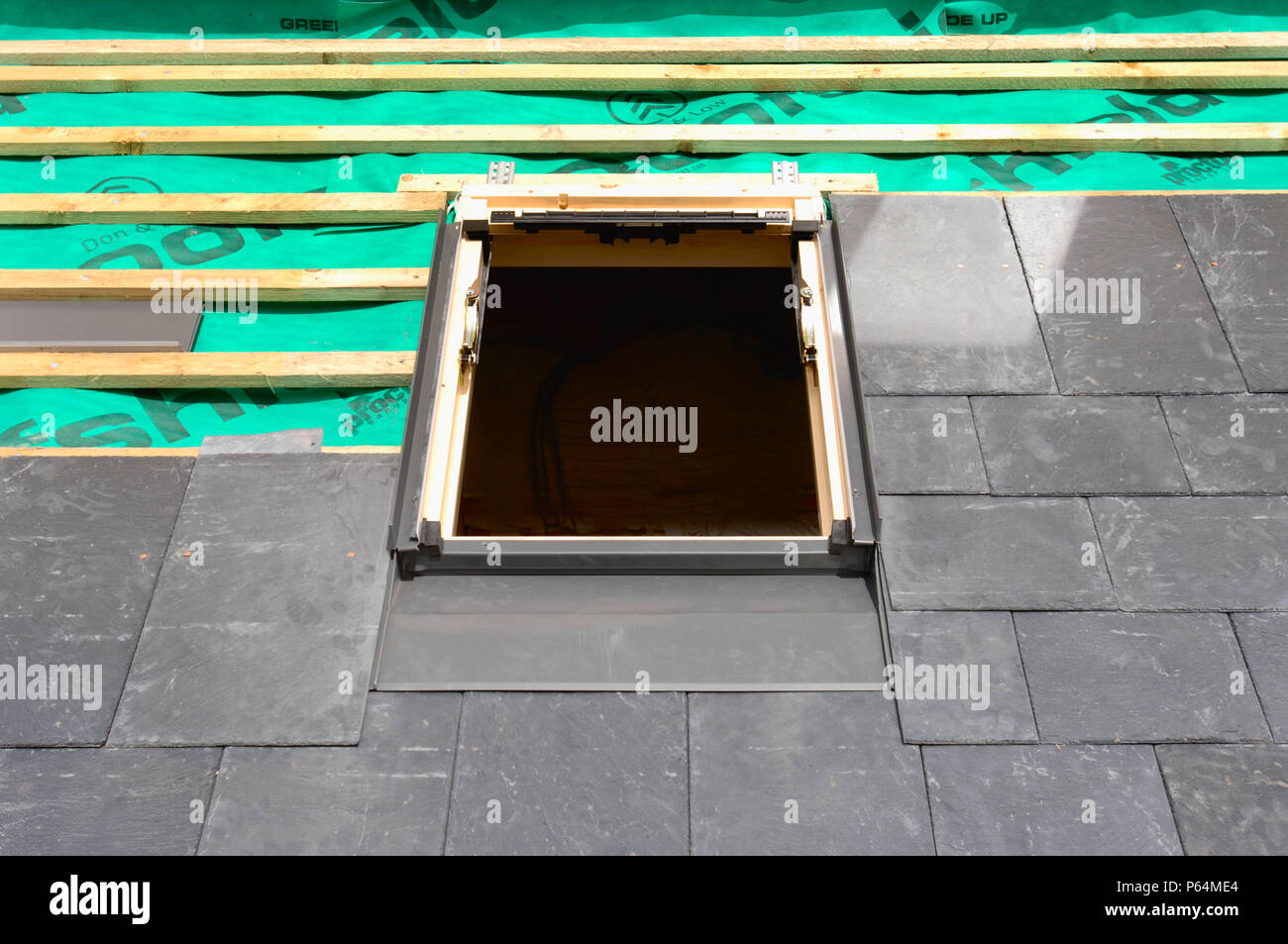Fitting a velux window on a slate roof under construction showing the ...