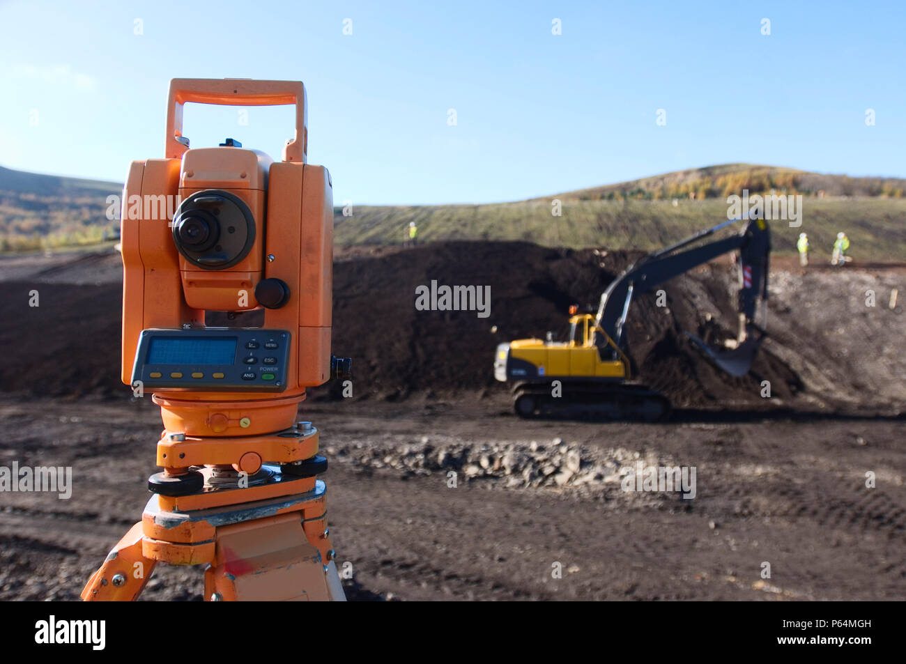 Theodolite and tracked earthmoving plant on brownfield site Stock Photo ...