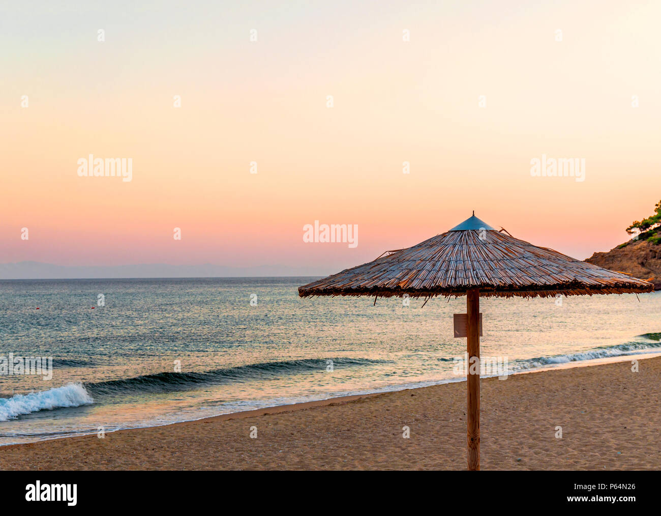 Reed umbrellas beach with blurred beach Stock Photo - Alamy
