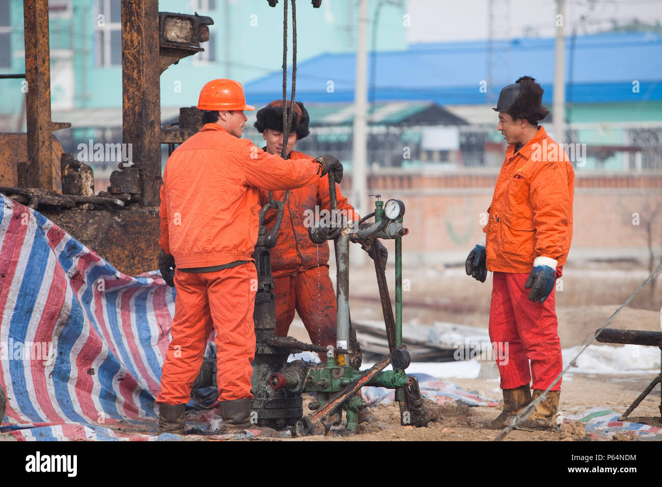 Oil workers drilling a new oil well in the Daqing oil field in Northern ...
