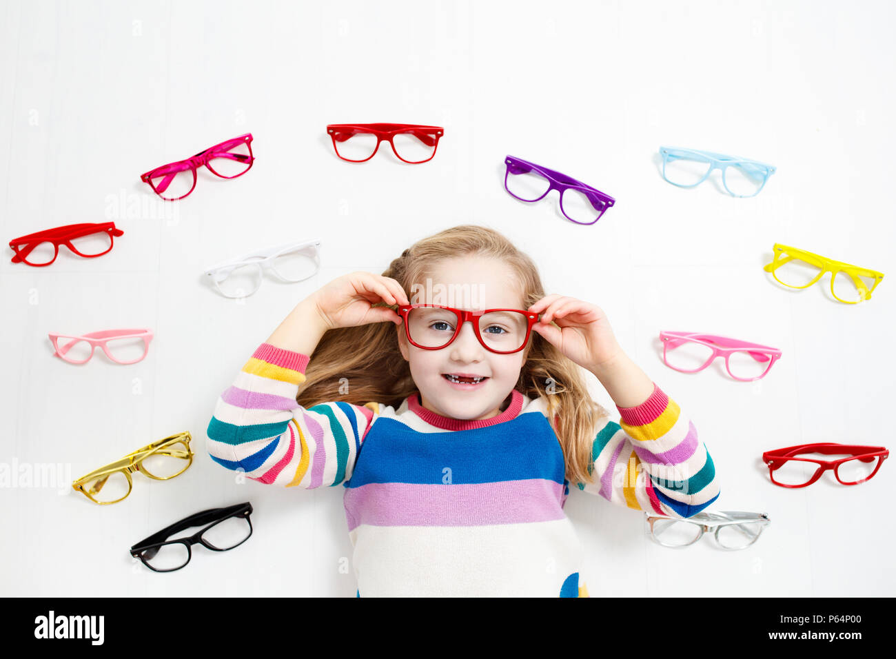 Child at eye sight test. Little kid selecting glasses at optician store ...