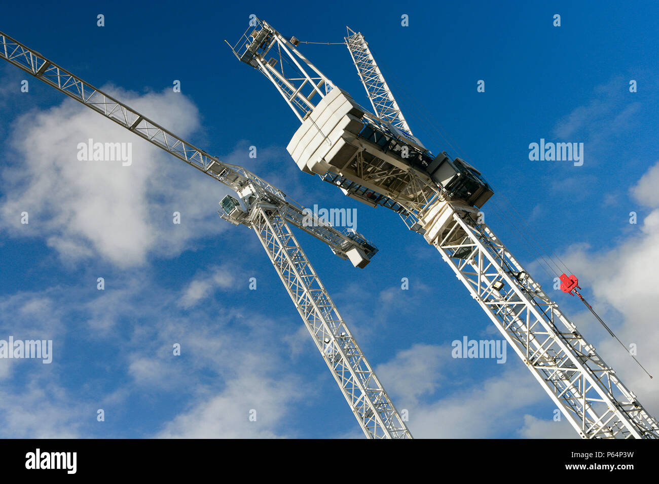 Two tower cranes with jib and pulley lifting attachment Stock Photo - Alamy