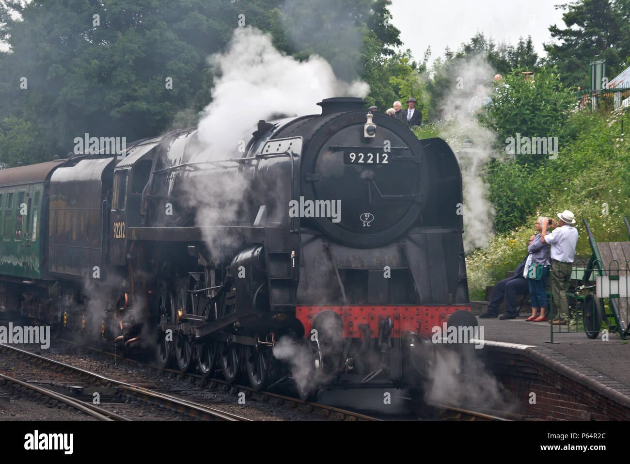 Steam locomotive 92212 pulling a passenger train at Ropley Station ...