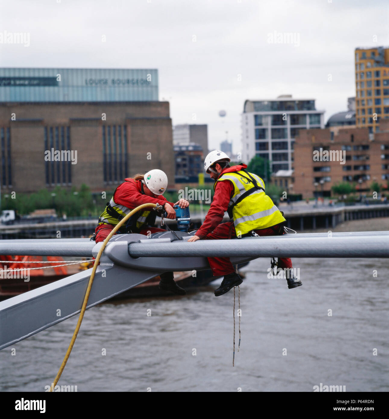 Fixing cables to cable clamp on Millennium Bridge, London, UK Stock ...