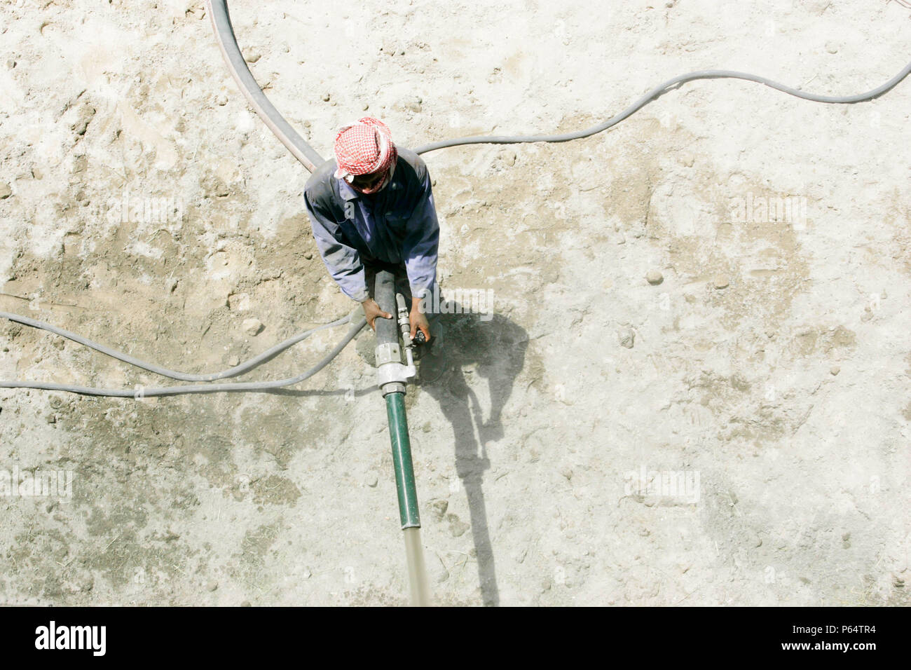 Construction worker spraying cement to a wall, Jordan Stock Photo - Alamy