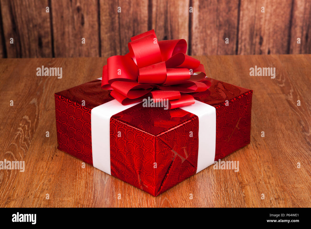 one large red gift box on a wood background Stock Photo - Alamy