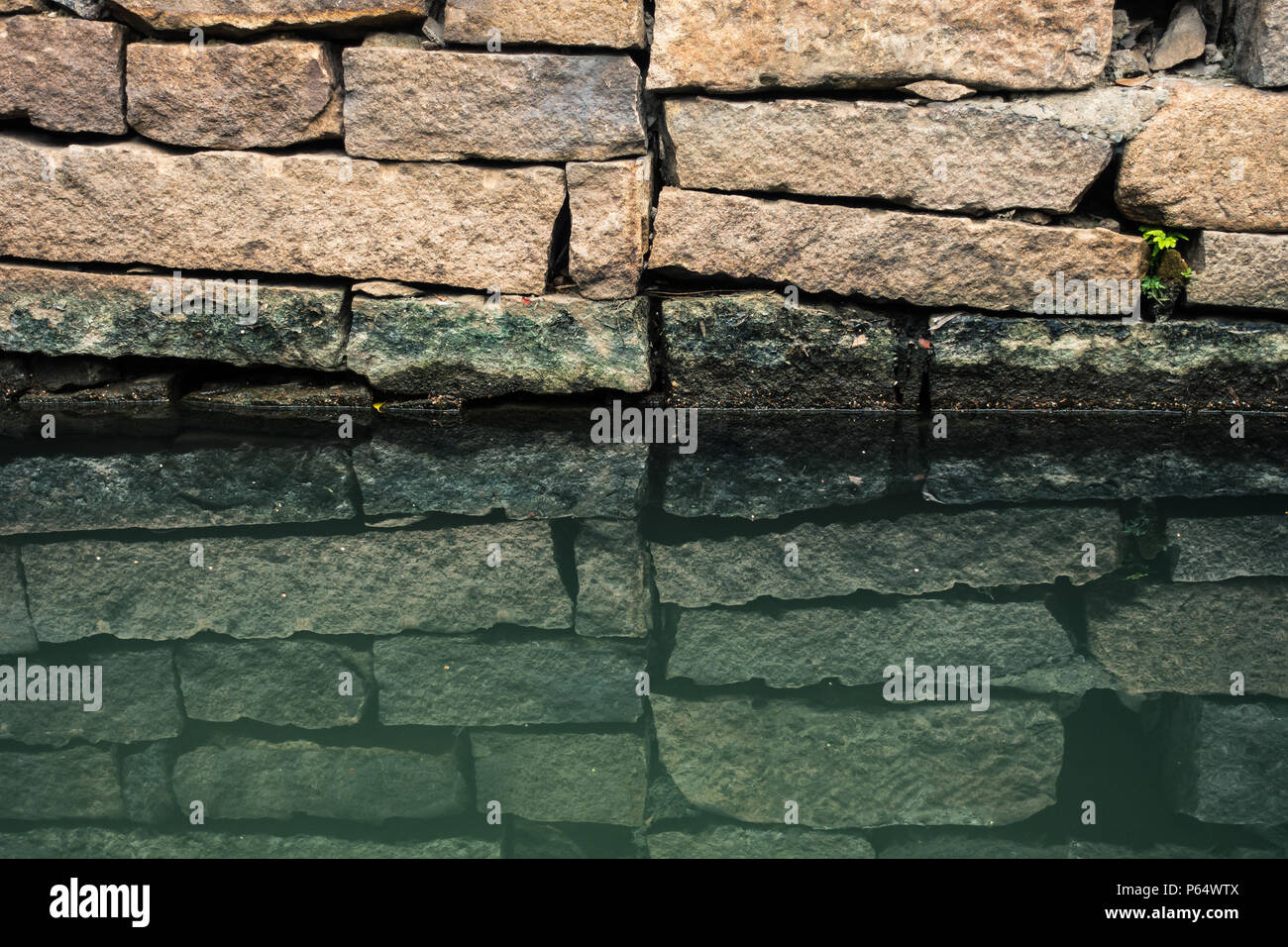 Bricks on Waterside and its Inverted Reflection in Water Stock Photo ...