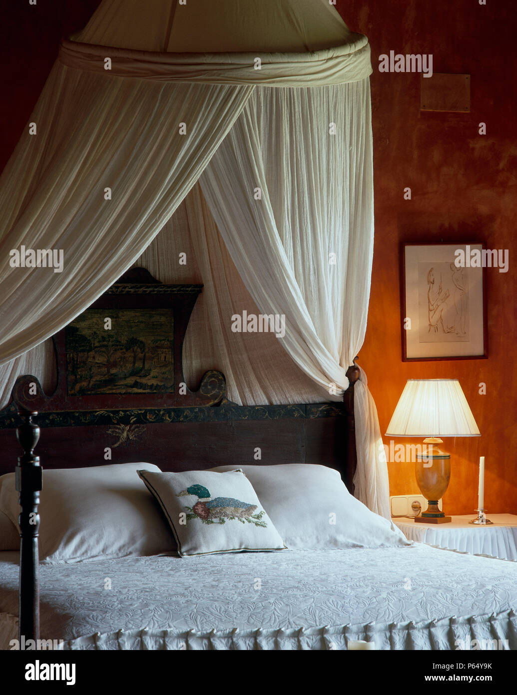 View of a cozy bed in an eclectic bedroom Stock Photo - Alamy