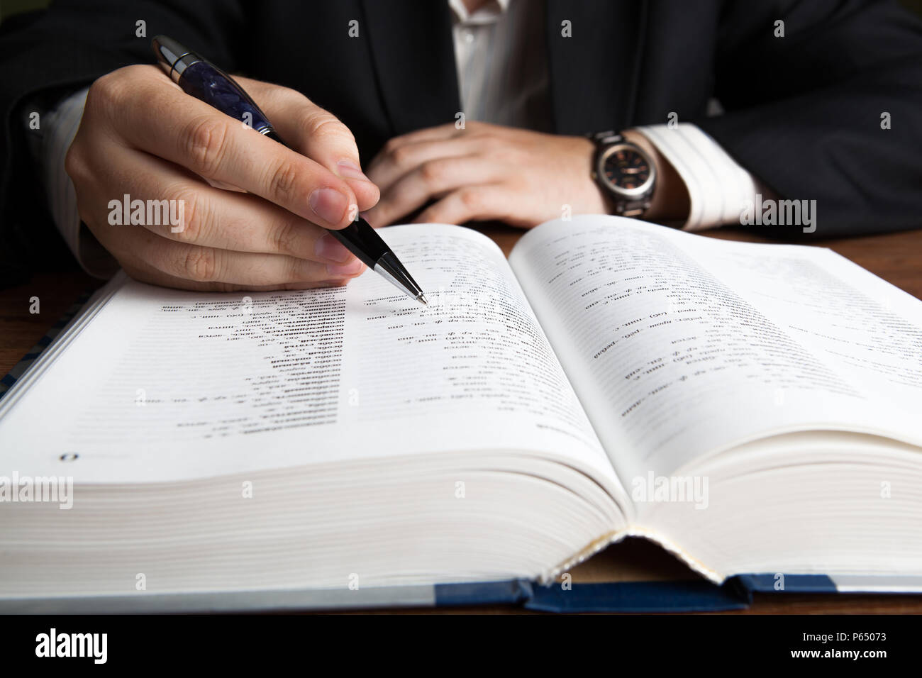 man looking in the large dictionary close up Stock Photo - Alamy