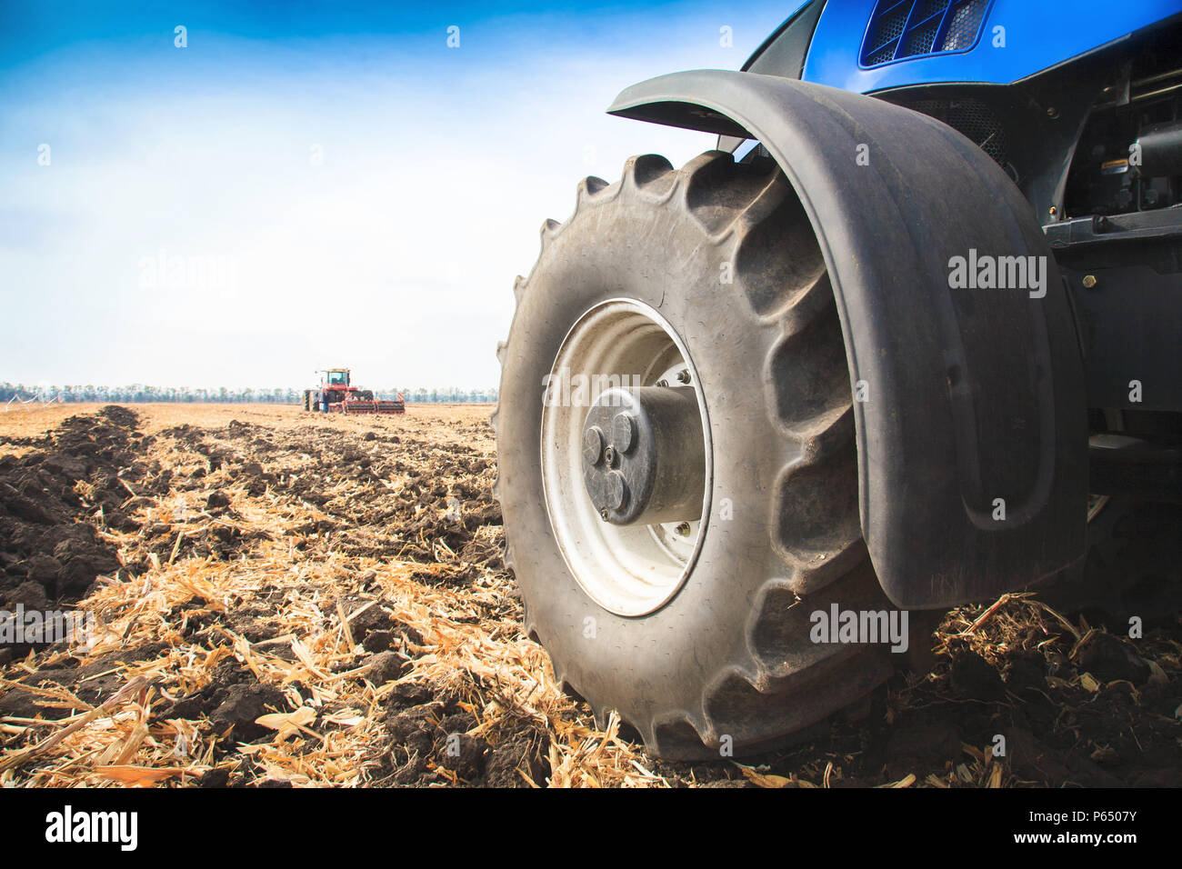 A wheel from a tractor working in the field close up. The concept of ...