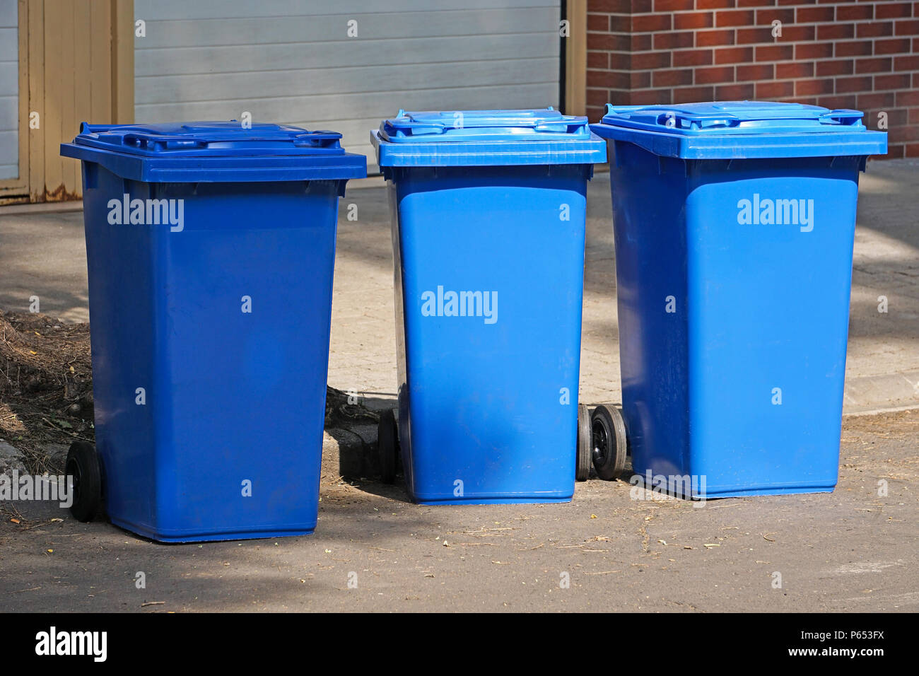 Blue garbage cans on the street in a row Stock Photo - Alamy