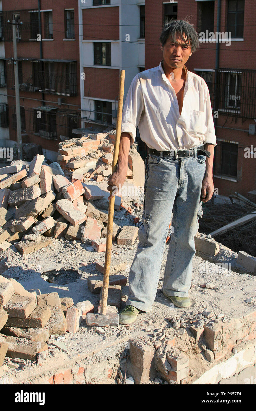 A Chinese migrant labourer working on the demolition of residential ...