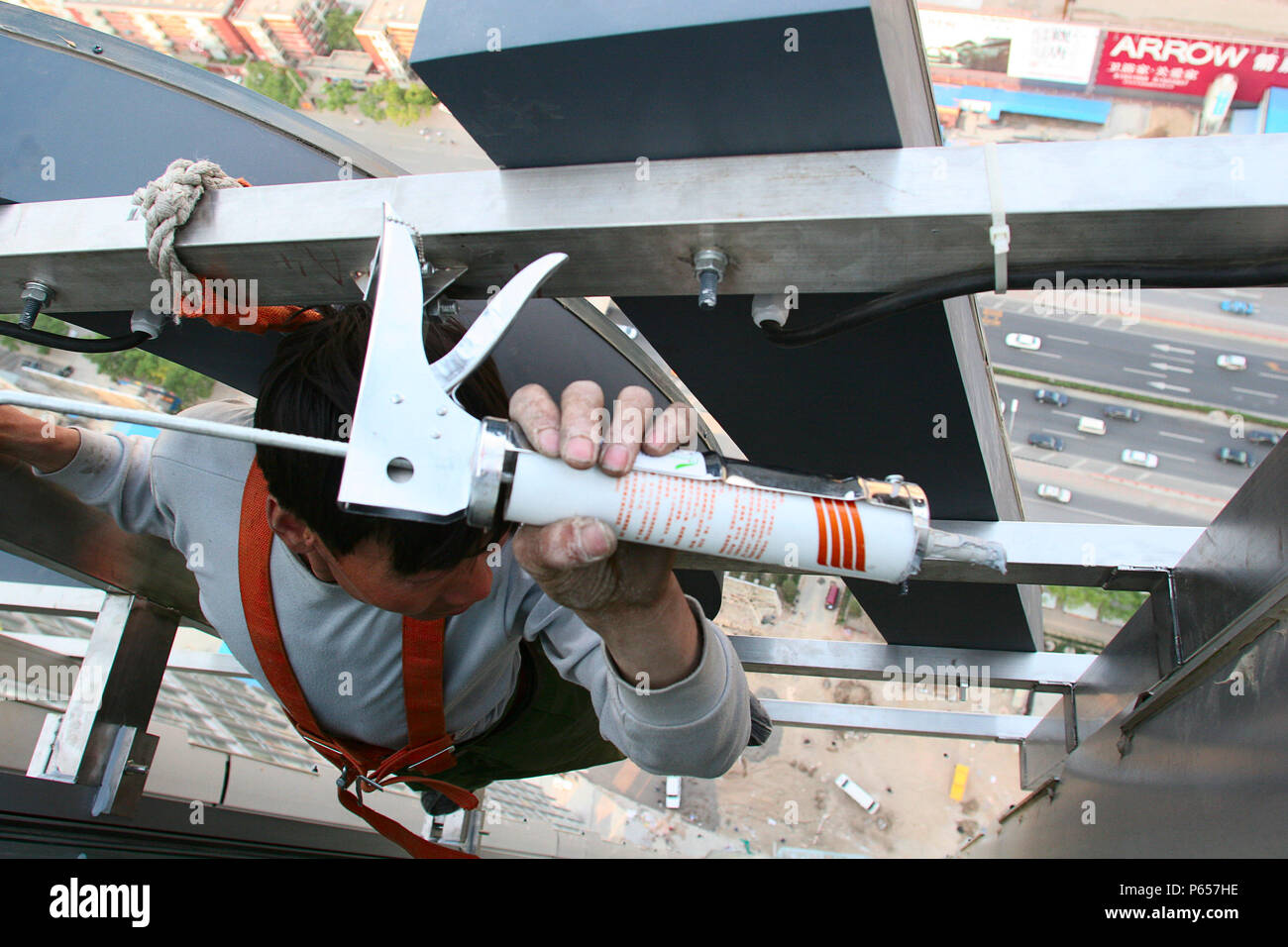 A construction worker installing a neon sign at Fortune Plaza in ...