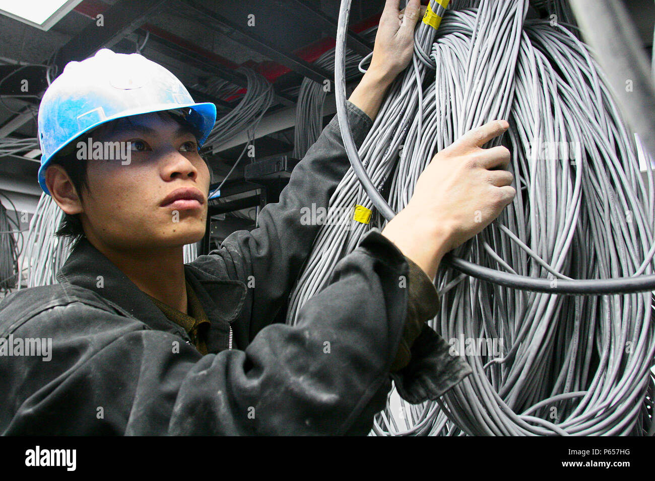 A construction workers installing wiring in a new office tower in ...