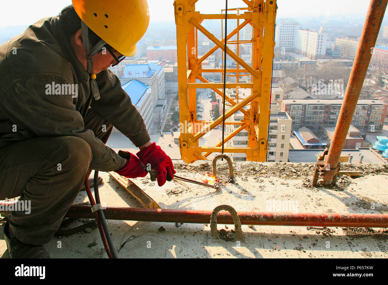 A worker clears excess steel rod of a building under construction in ...