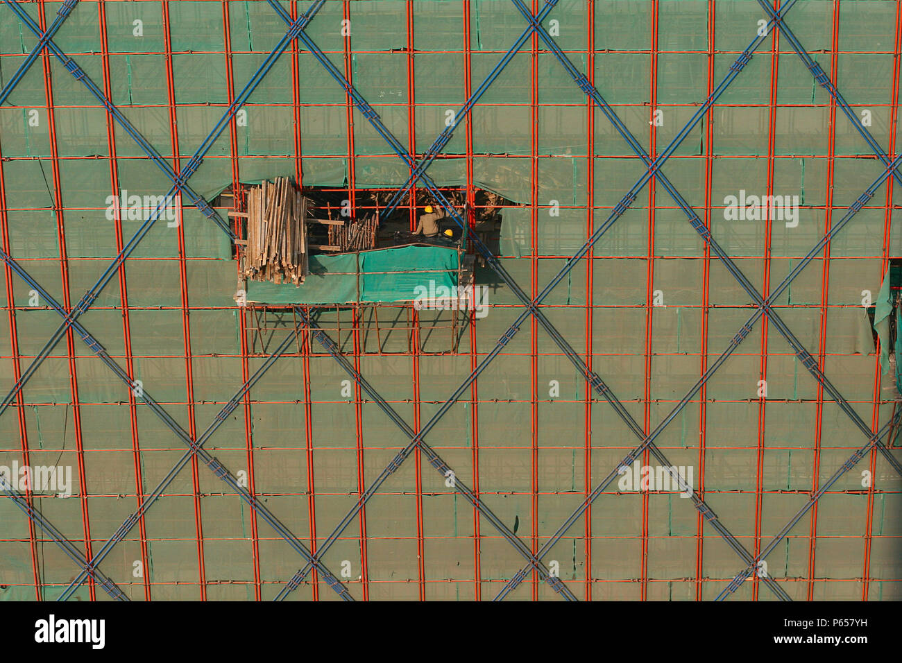 Workers prepare used wooden struts for lifting by crane on the Facade ...
