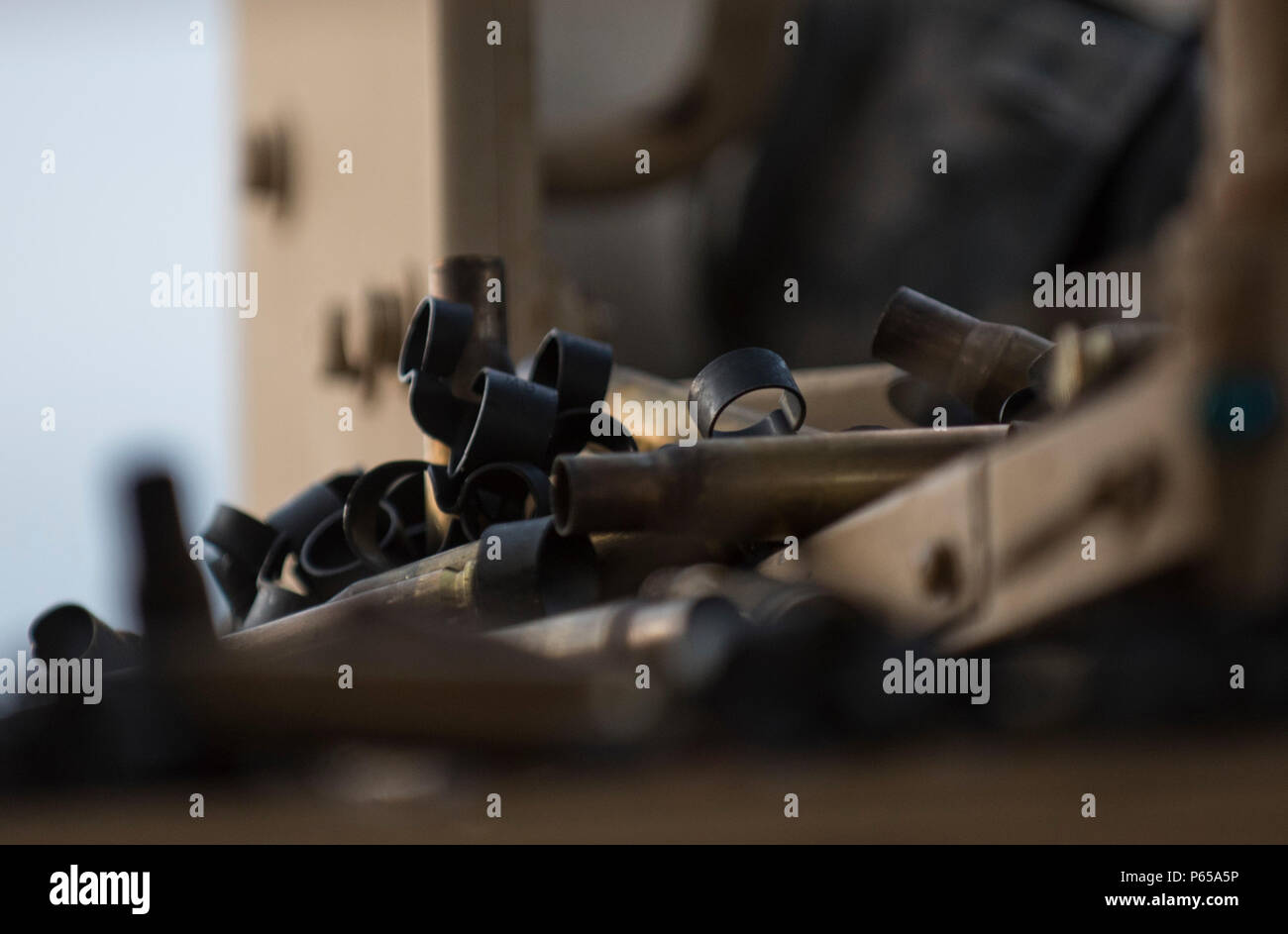 Shell casings from a .50-caliber machine gun pile up by a vehicle ...