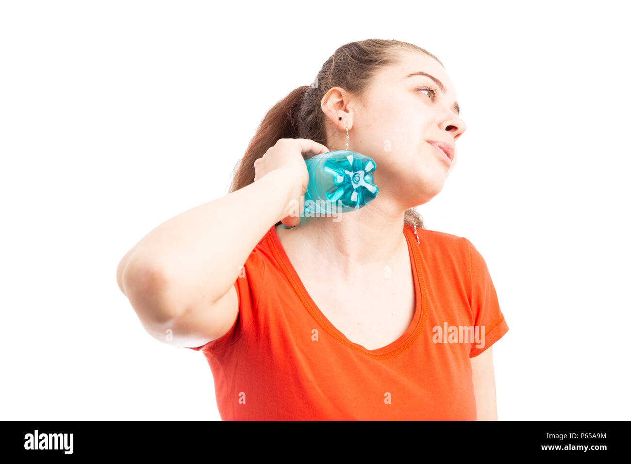 Sweating attractive young woman cooling with bottle of water touching ...