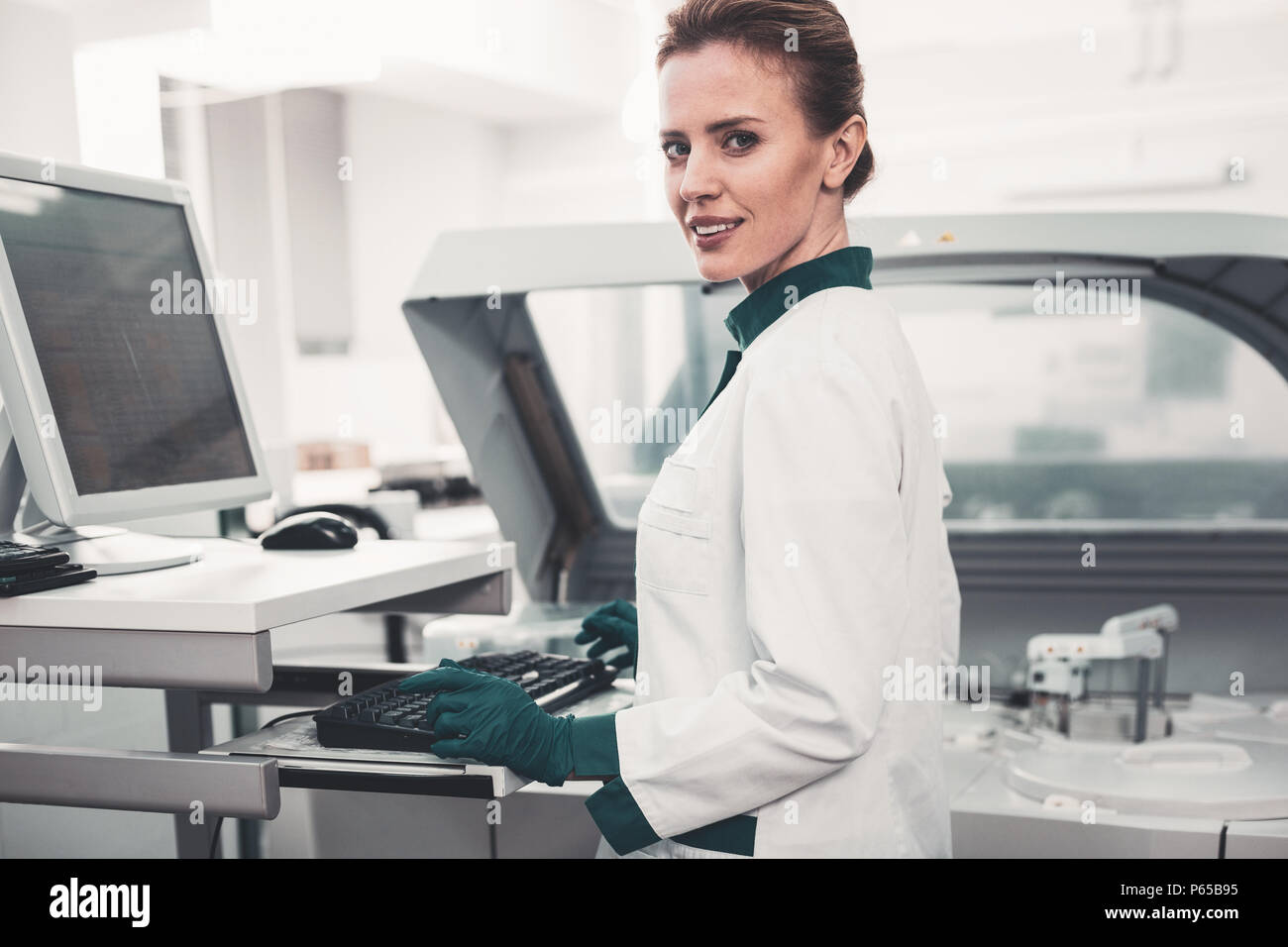 Waist up of pleased lab worker using computer Stock Photo - Alamy