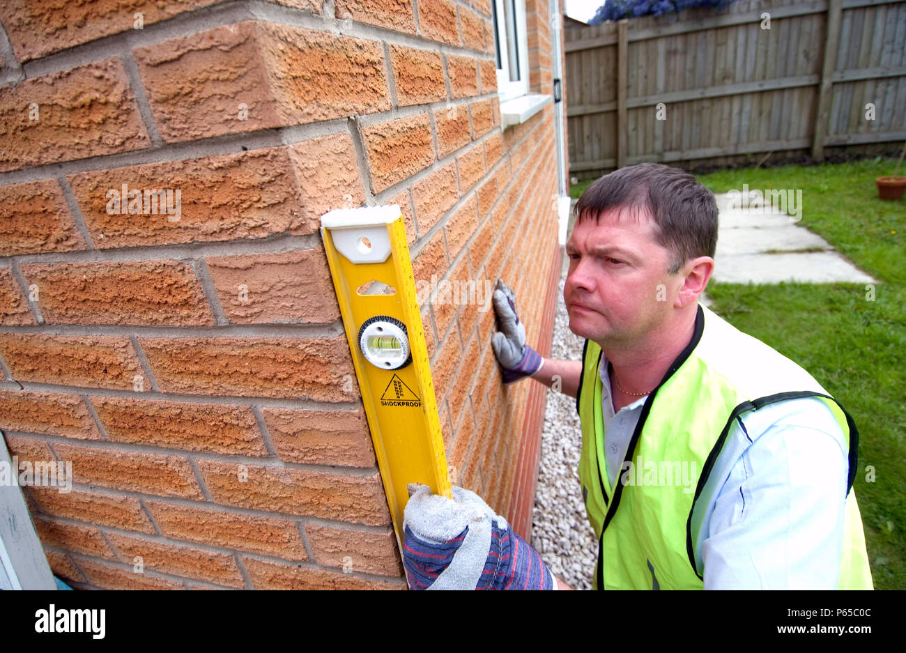 Builder using a spirit level Stock Photo - Alamy