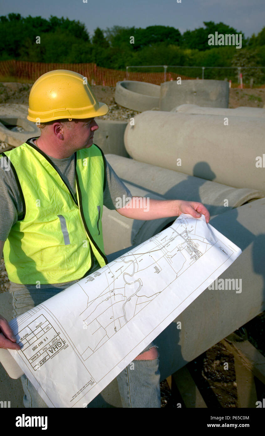 Building technician checking plan on site Stock Photo - Alamy