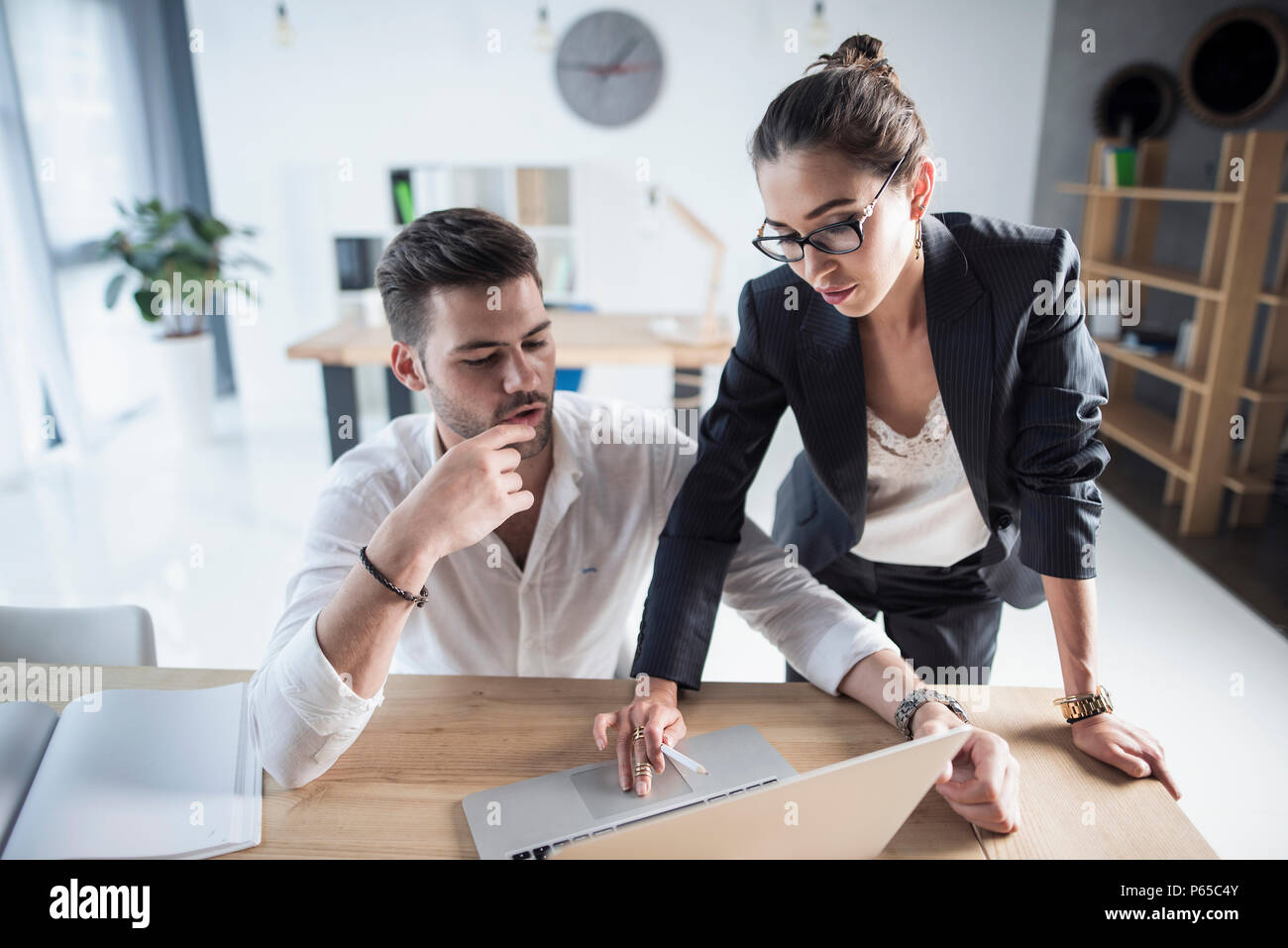 Coworkers on a project working together on the same laptop computer ...