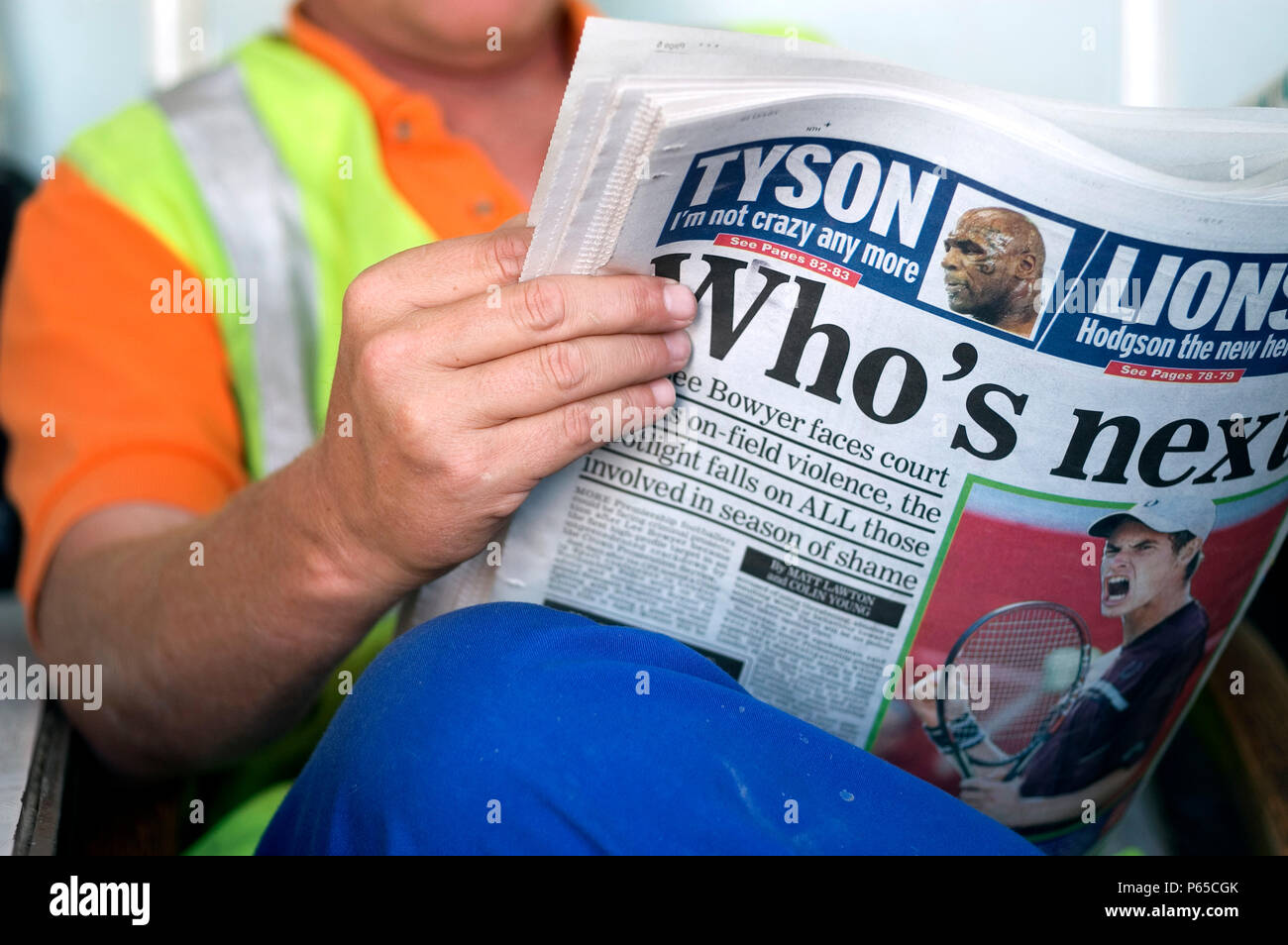 Construction worker reading the newspaper Stock Photo - Alamy