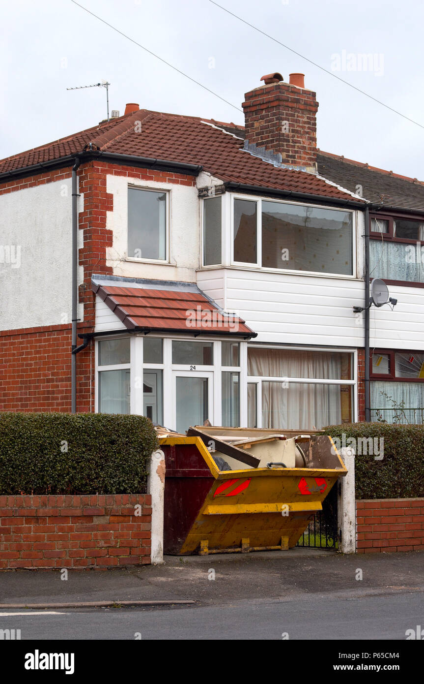 Skip in front of a house under refurbishment Stock Photo - Alamy