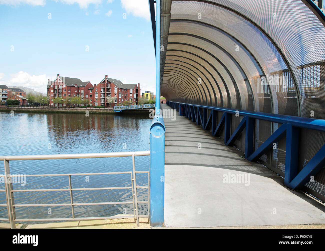 Pedestrian footbridge across River Lagan and riverside apartments ...