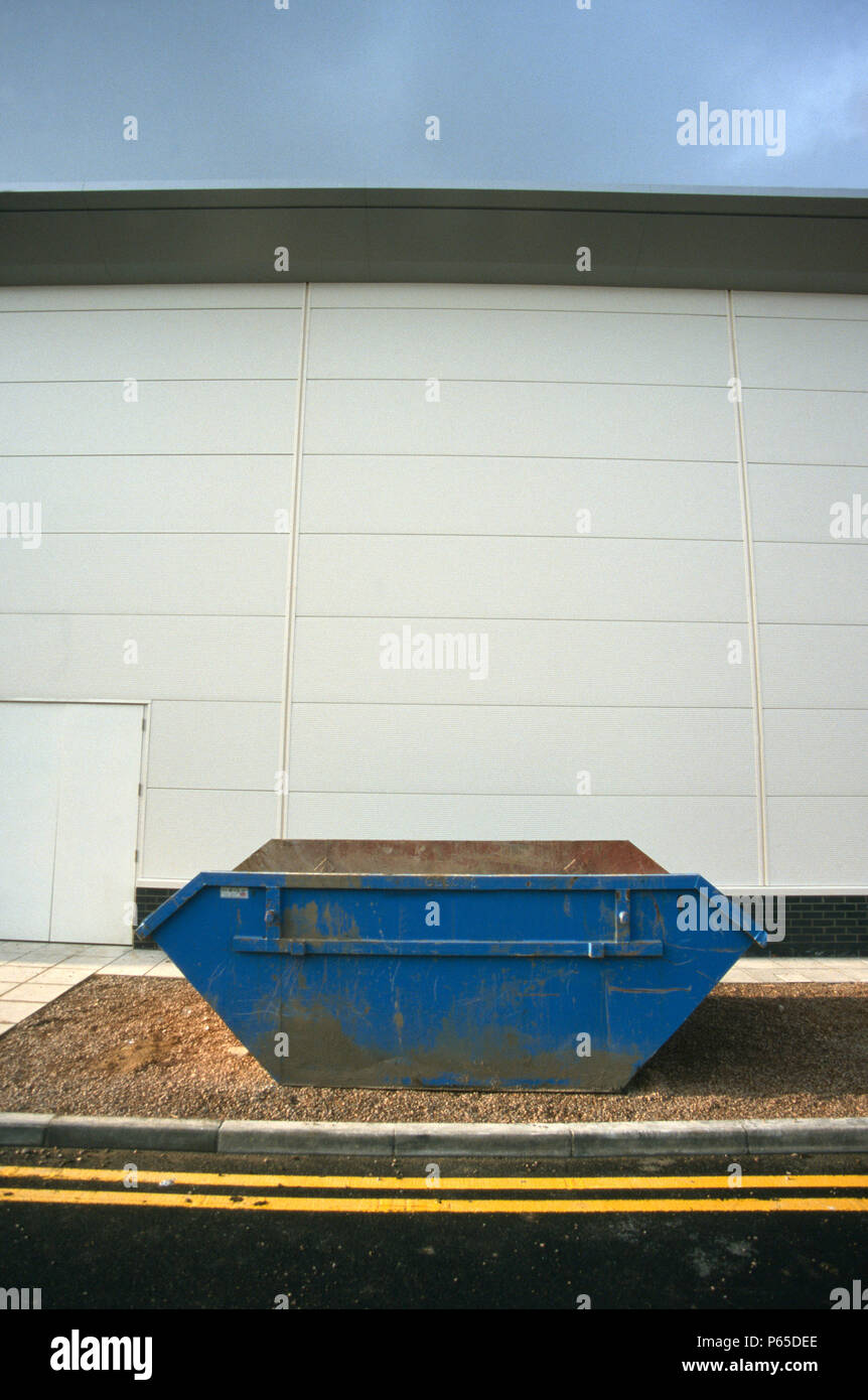 Skip alongside new building Stock Photo - Alamy