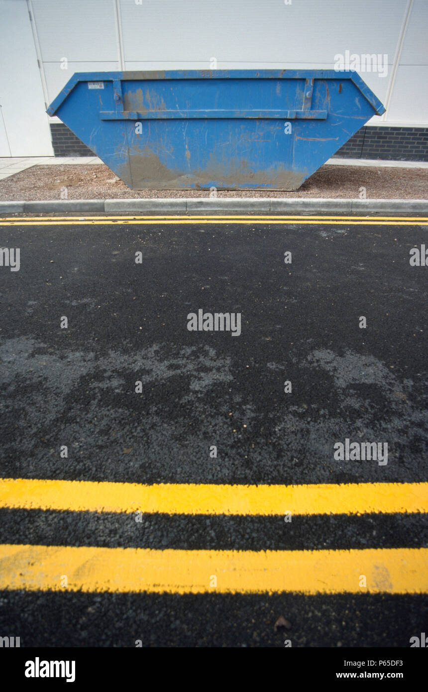 Skip alongside new building Stock Photo - Alamy