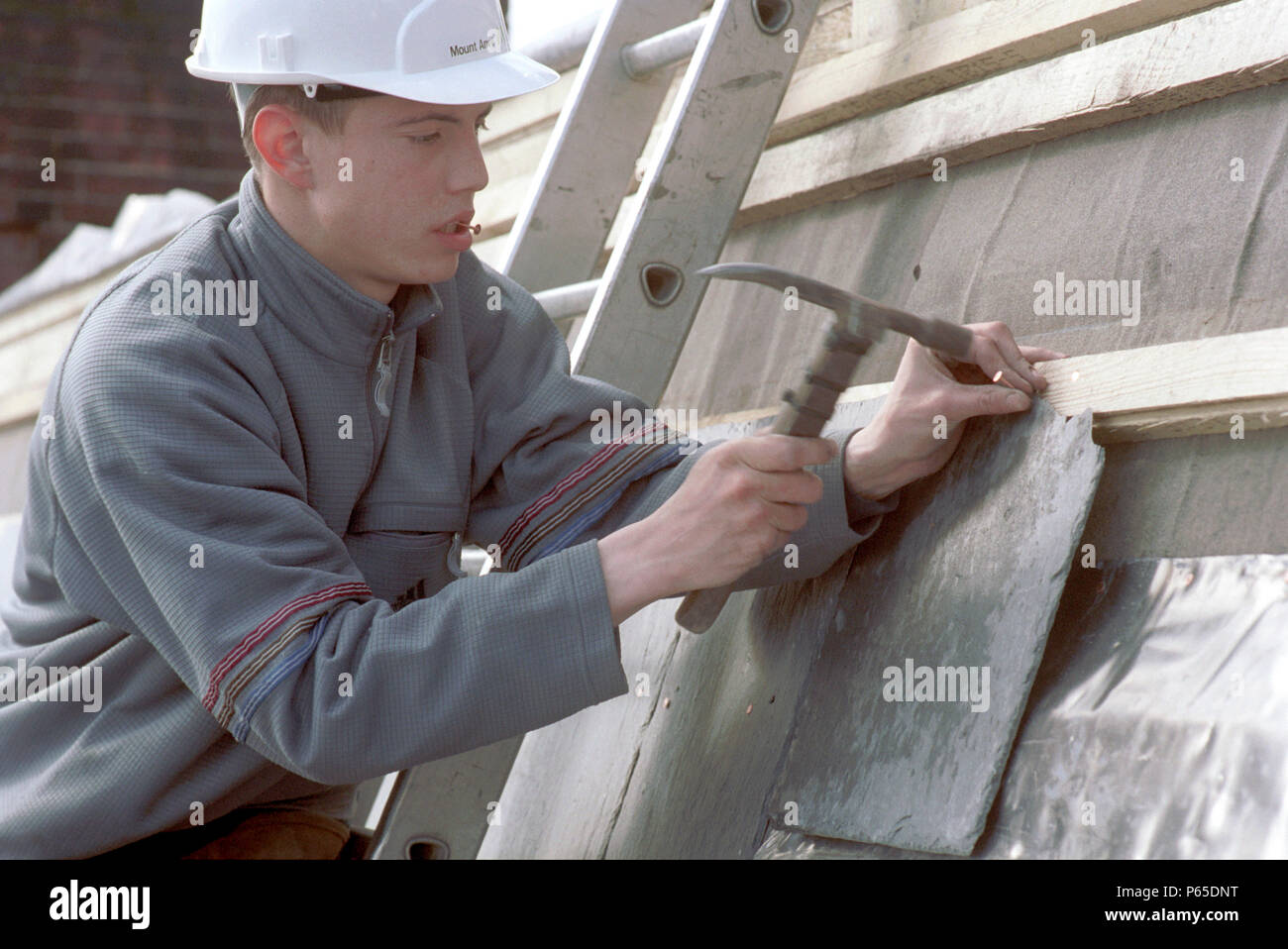 Roofing. Nailing slates onto battens Stock Photo - Alamy