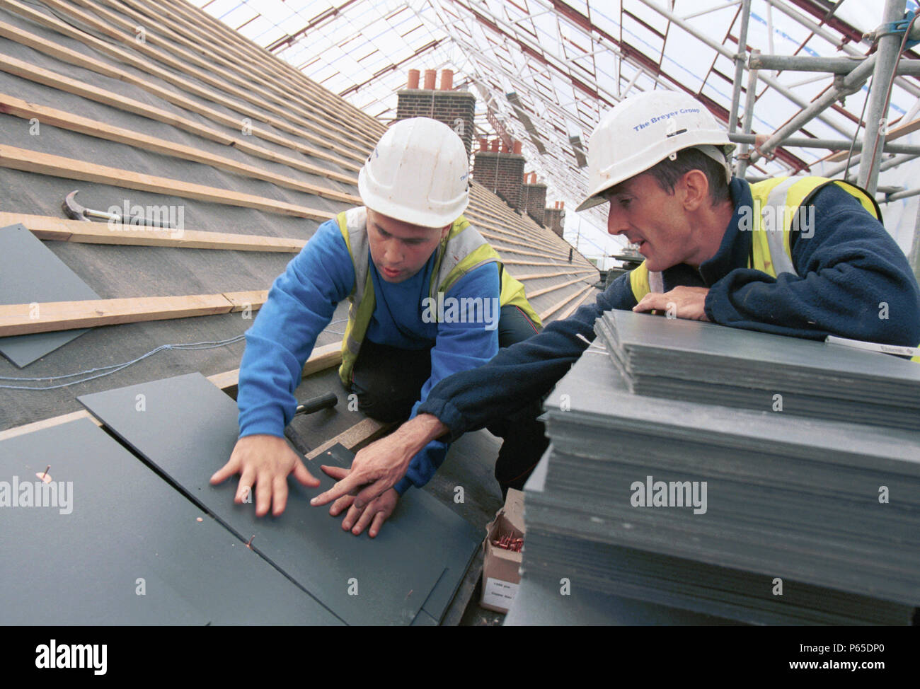 Roof Slating.Young apprentice learning trade skills on site Stock Photo ...